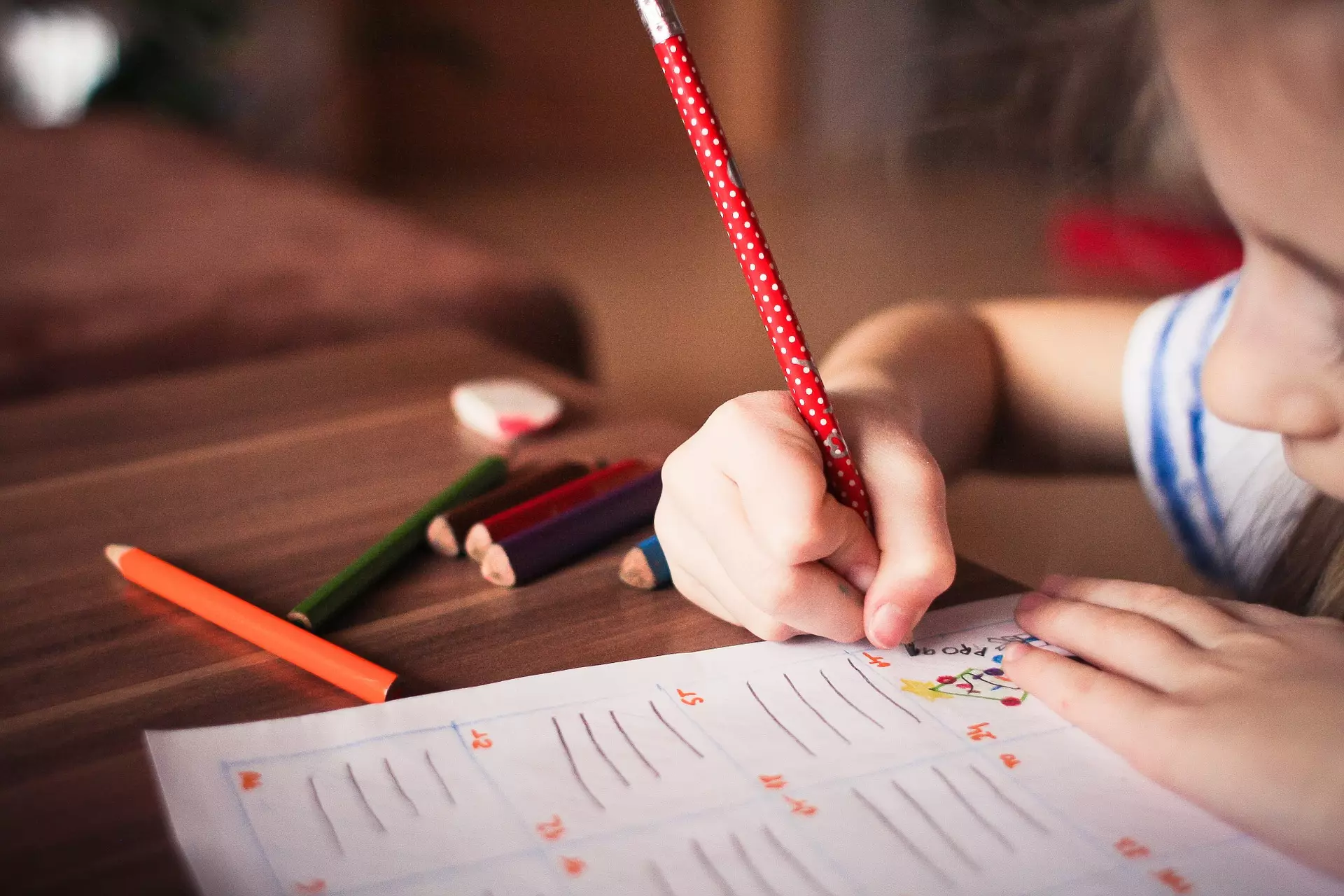 अपने एडीएचडी बच्चे के अध्ययन स्थान को बढ़ाएं, जैसे यह लड़की अपना होमवर्क कर रही है