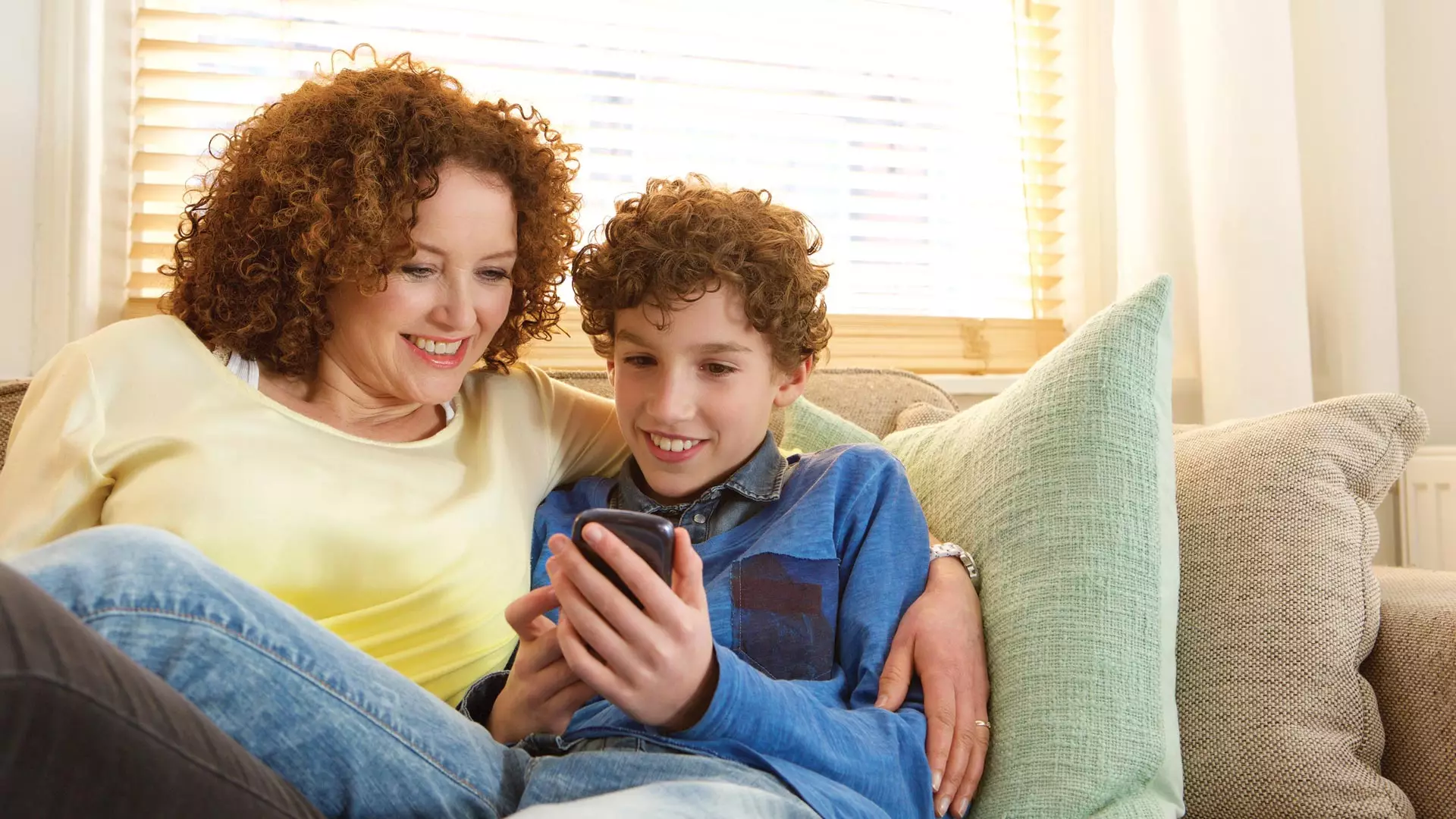 Äiti opettaa lapselleen, kuinka saada ystäviä matkapuhelimen avulla