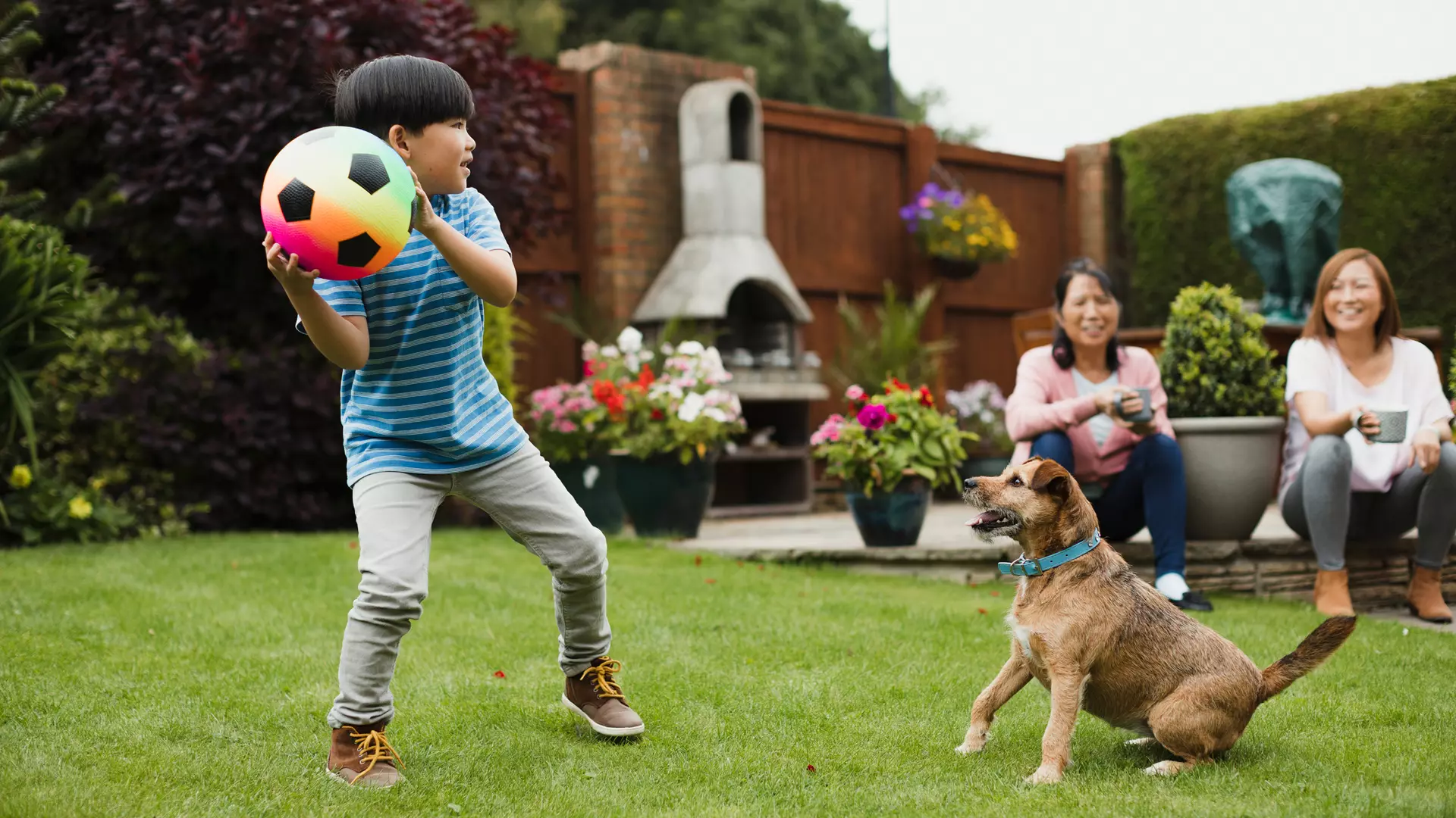 ADHD-ga poiss, kes mängib oma koera ja jalgpallipalliga õues, veetes edukat suve
