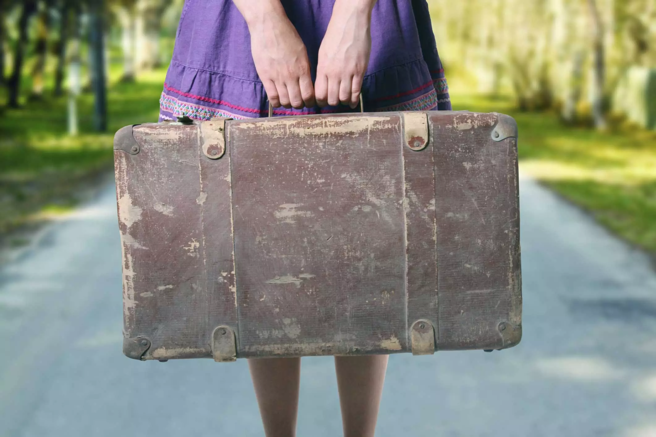 Unha moza adulta con TDAH sostén unha maleta porque volve a casa