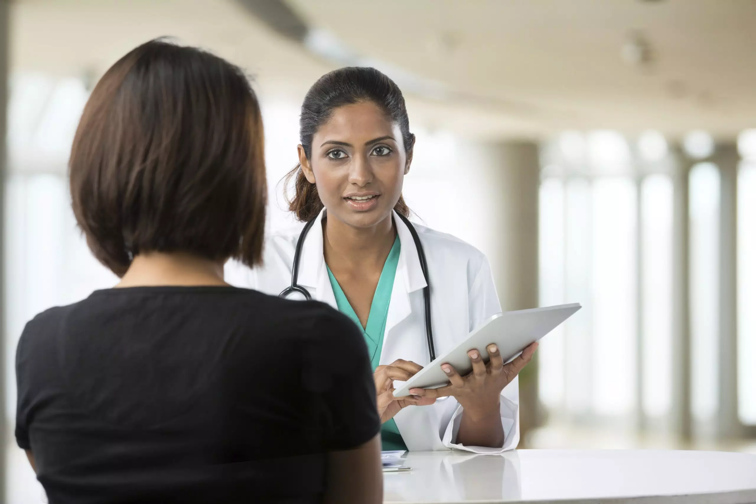 Un médico consulta cun paciente sobre a posibilidade de TDAH adulto.