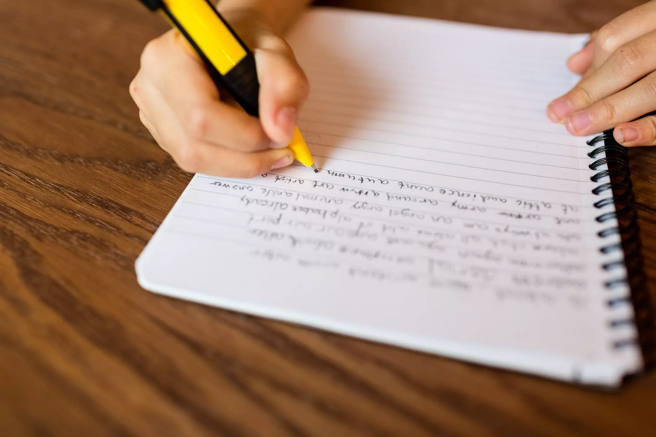 En tonåring med ADHD skriver ner något för att avsluta sitt skolarbete