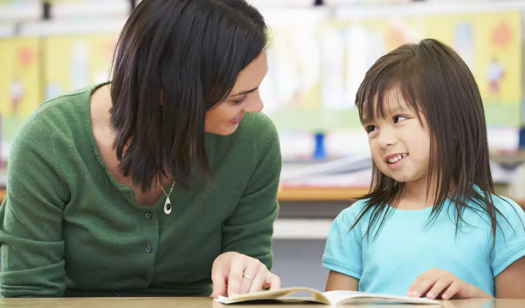 Õpetaja abistab koolis ADHD-ga tüdrukut