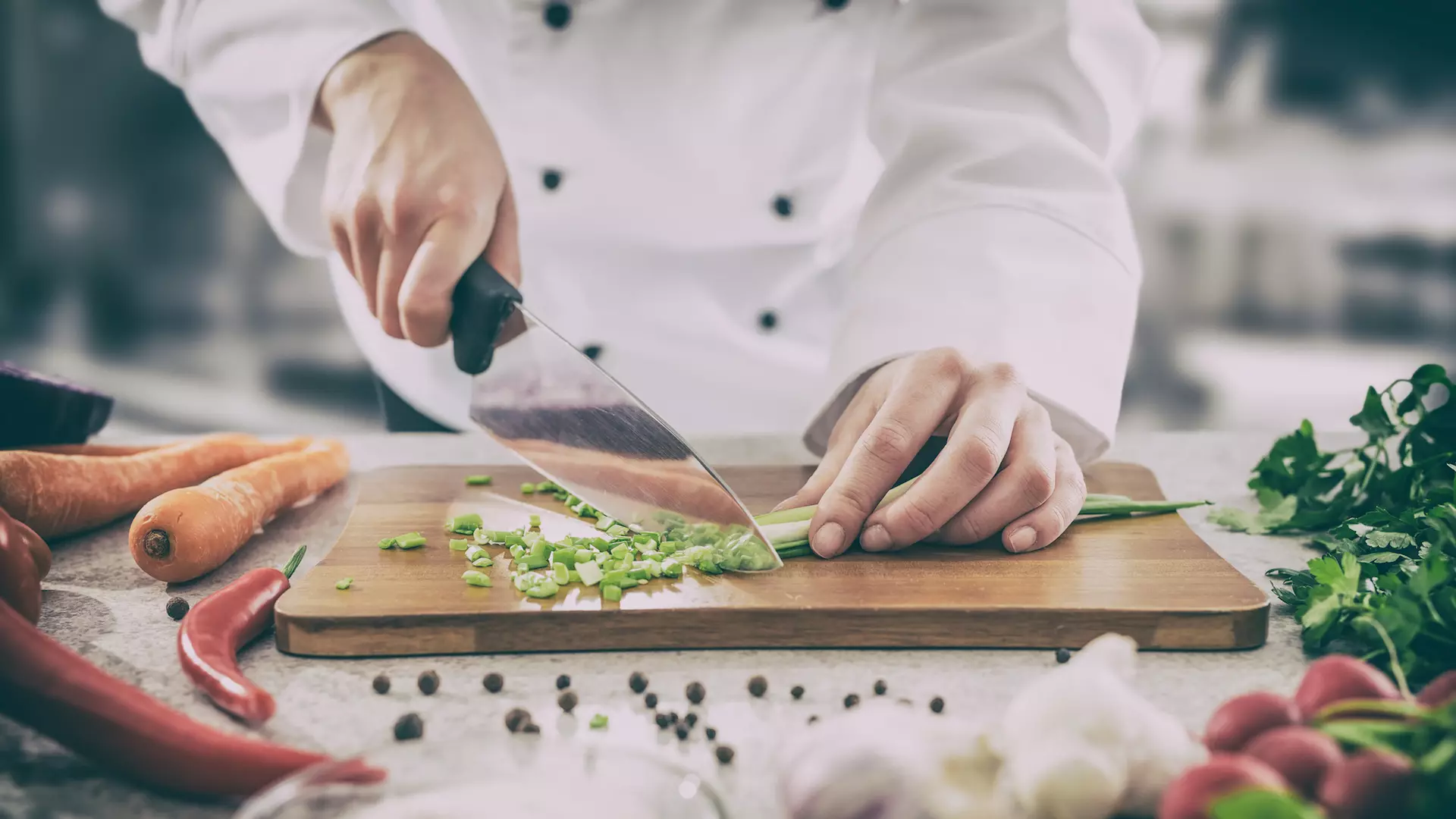 Een chef-kok die uien snijdt na het vinden van de juiste baan
