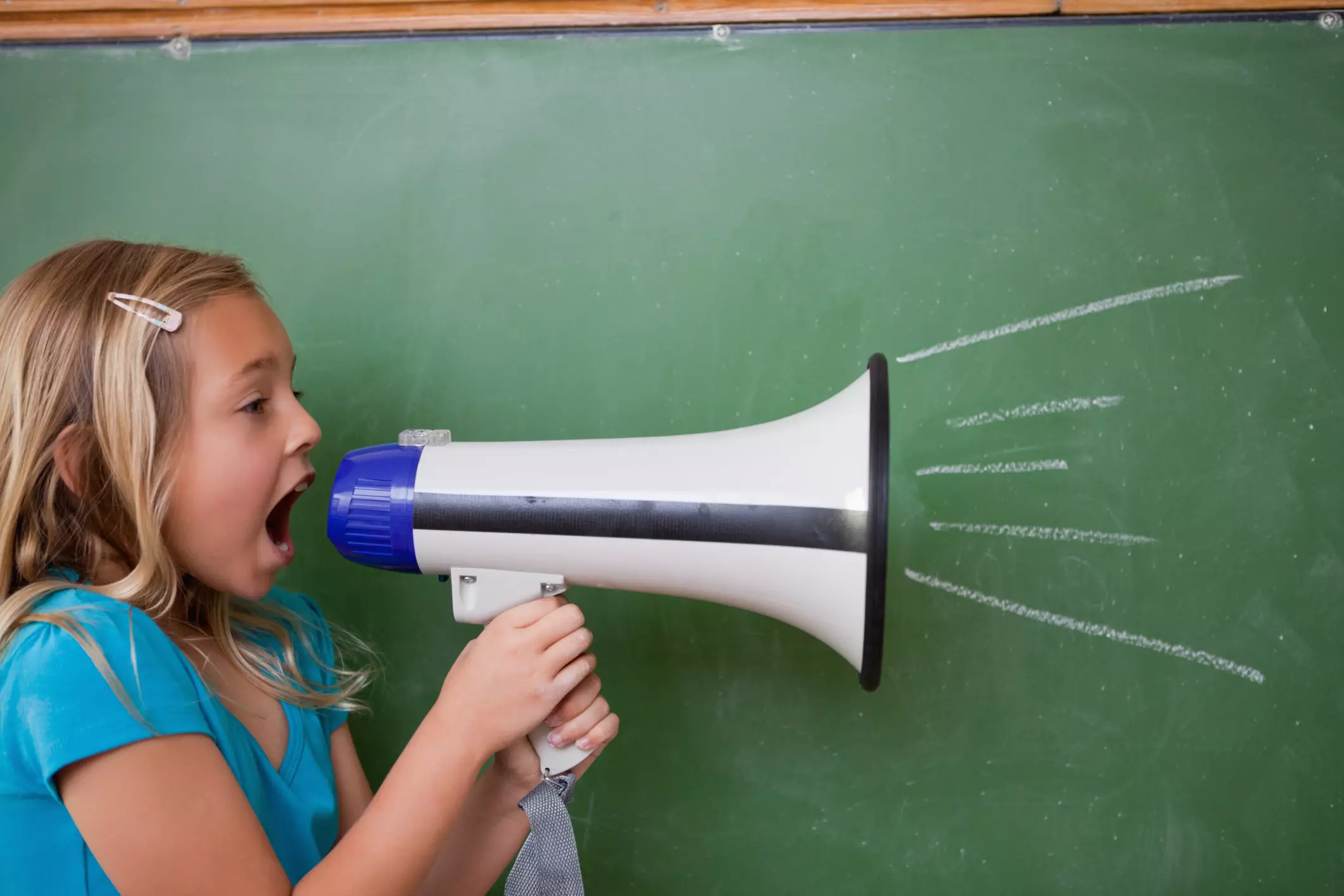 Девочка с СДВГ кричит и ведет себя импульсивно в классе, используя мегафон.