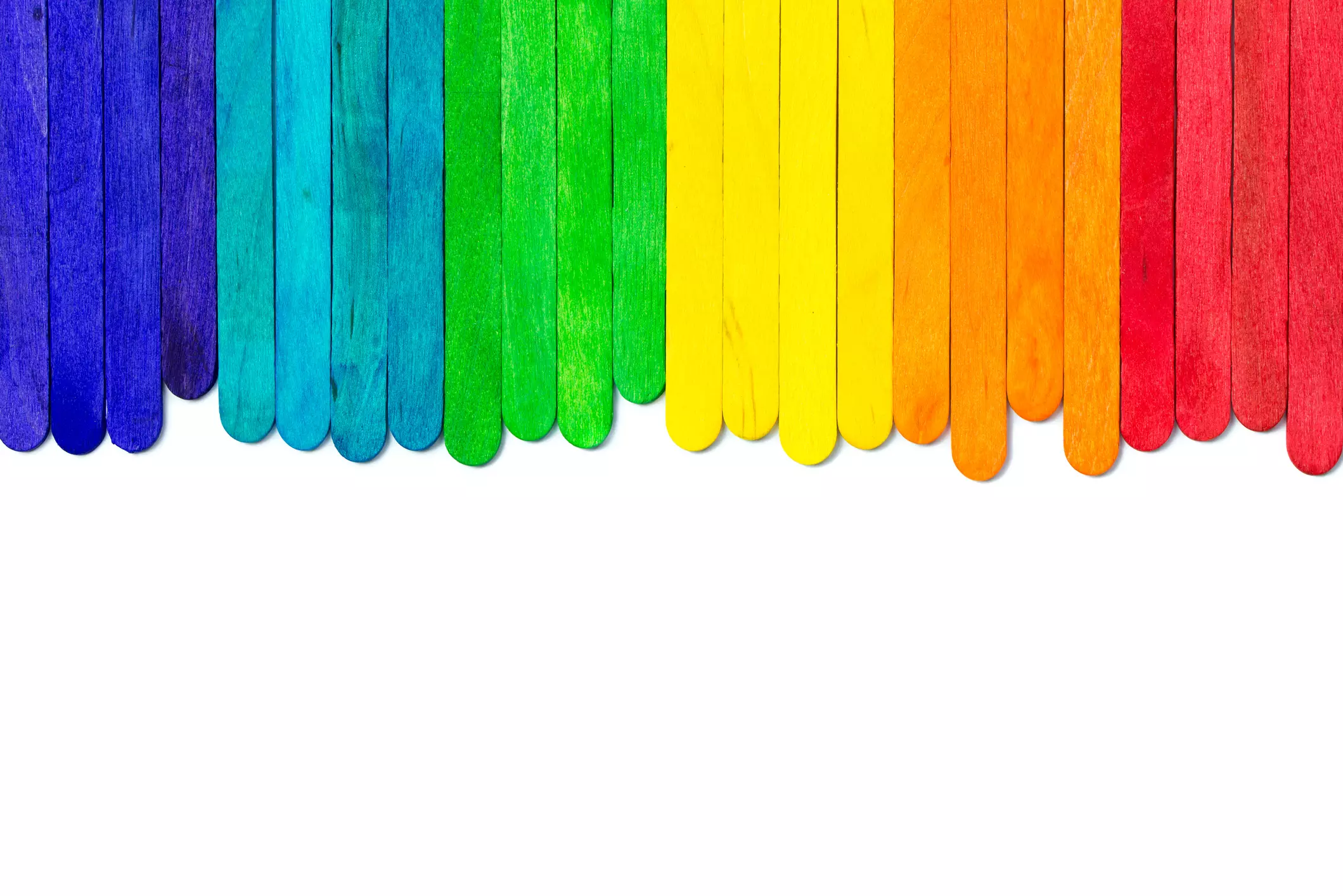 Bâtonnets de popsicle en bois coloré sur fond blanc