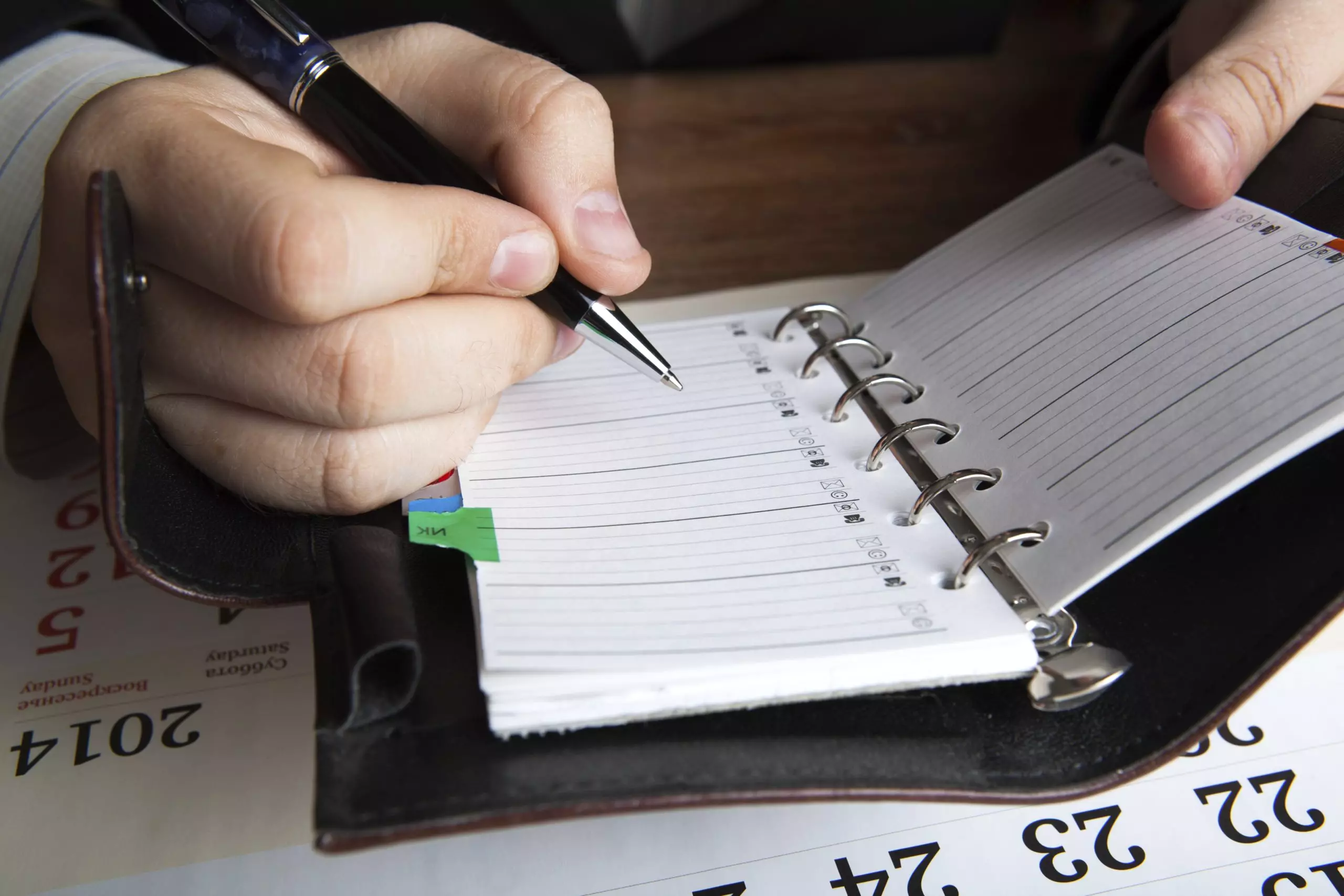 एक व्यक्ति अपनी पता पुस्तिका में चीजें लिखते समय कार्य पर बने रहने का अभ्यास करता है।