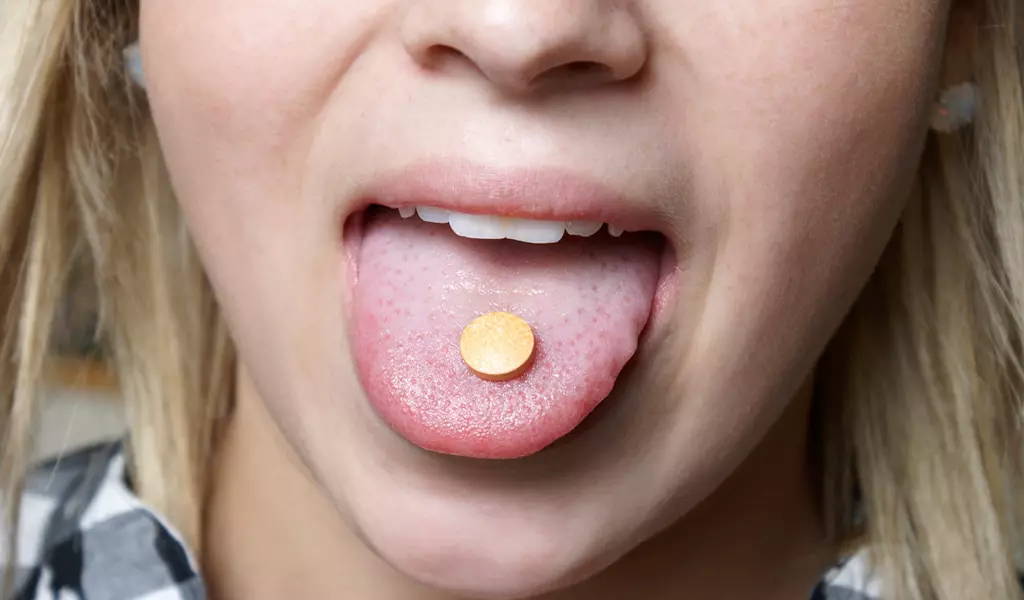 ADHD-s nő kidugja a nyelvét, és gyógyszert ad rá