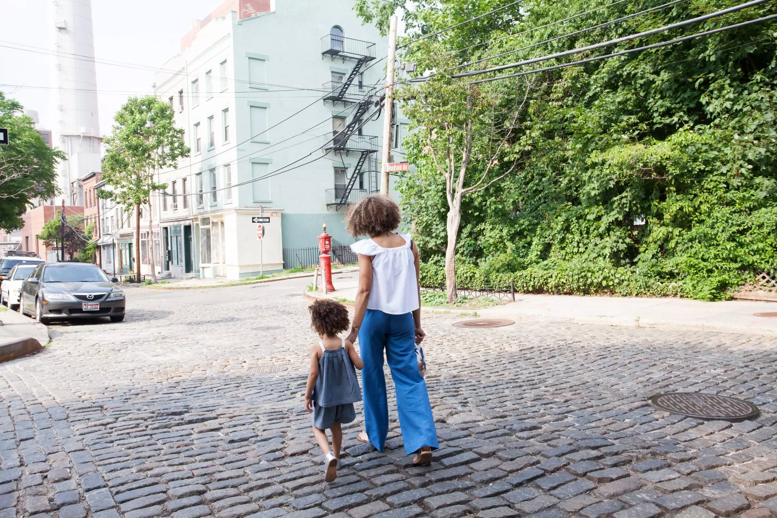 Майка помага на дъщеря си да се справи с ADHD, като се разхожда по калдъръмена улица
