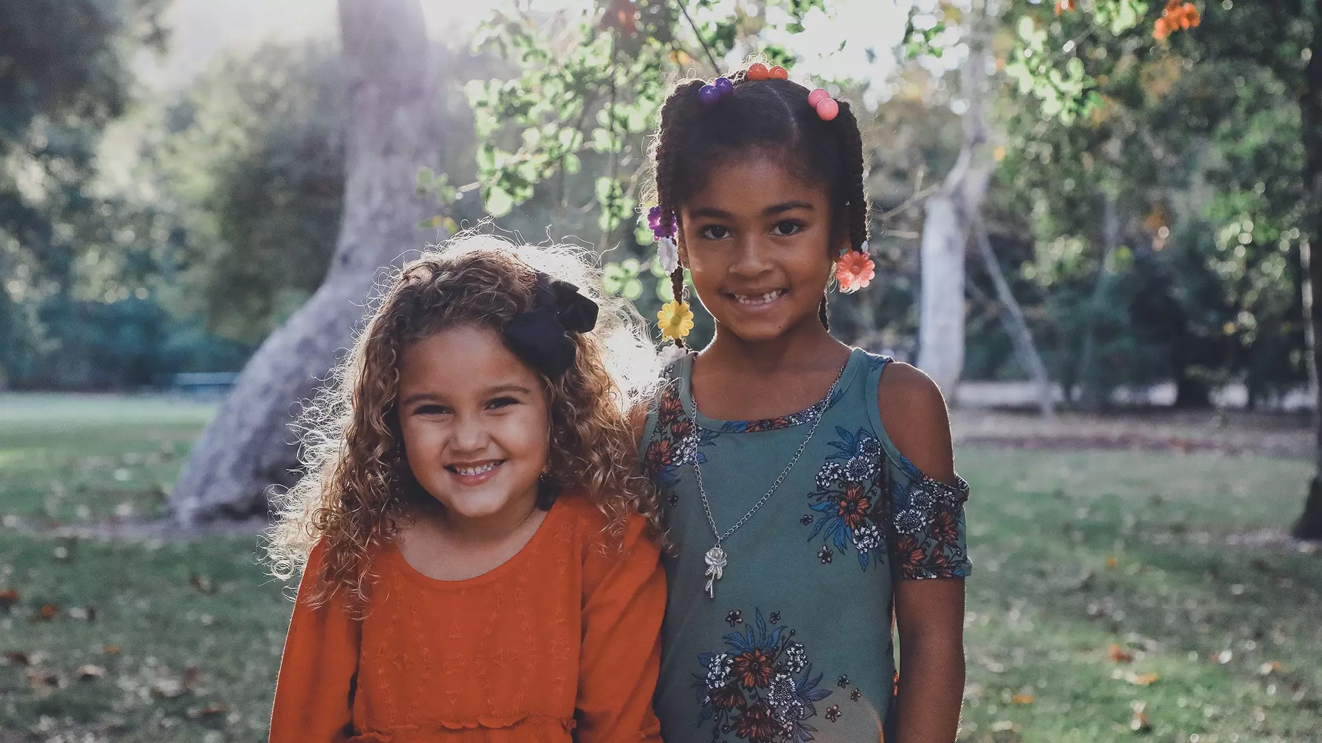 Duas garotas com TDAH sorriem depois de aprender boas maneiras.
