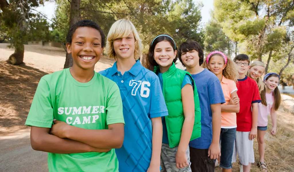 Crianças no acampamento de verão com TDAH sorrindo e em pé na fila do lado de fora