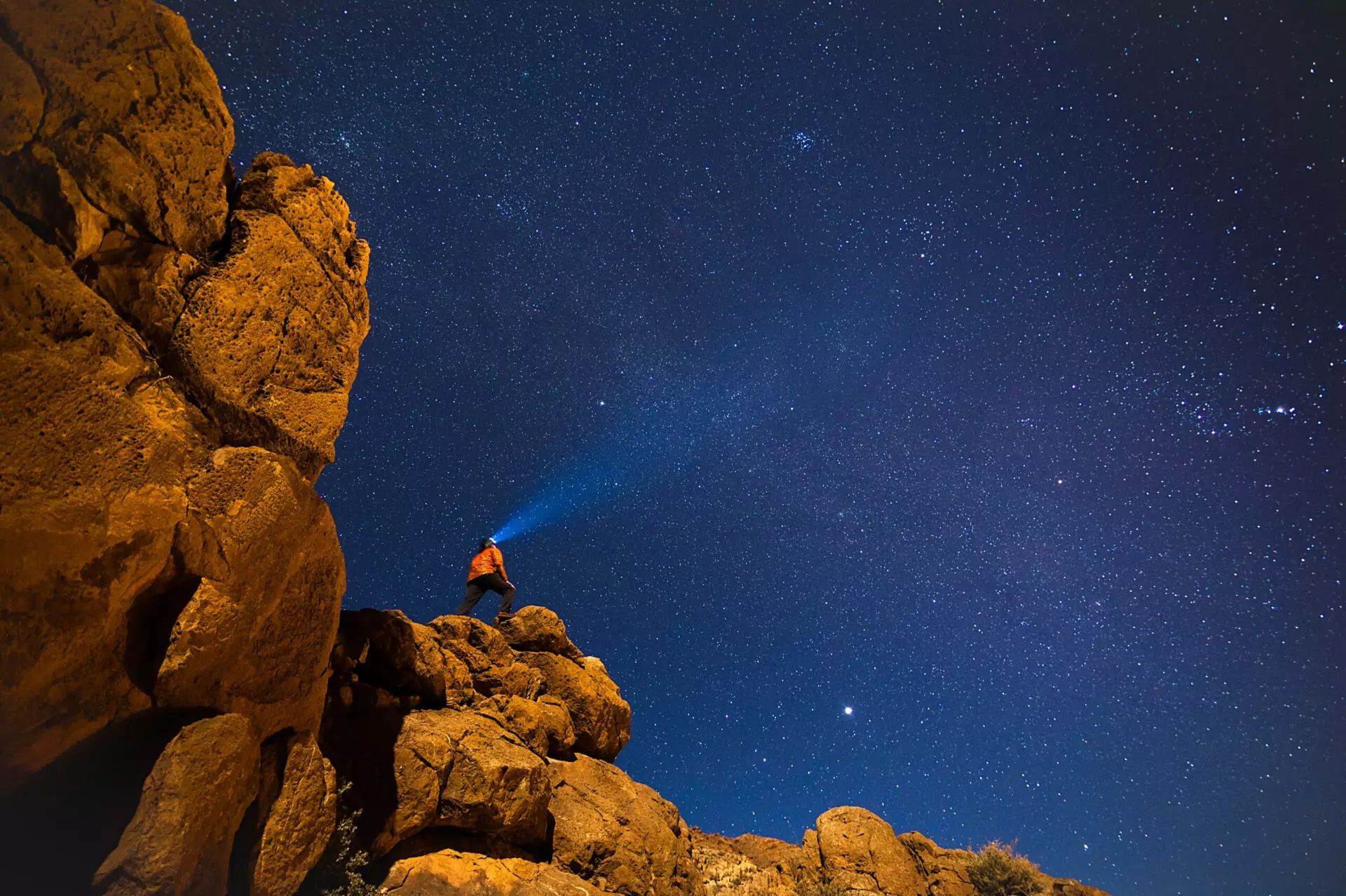 젊은 남자는 모로코에서 밤 하늘에 그의 헤드램프를 켭니다. Jacob Kupferman / 게티 이미지