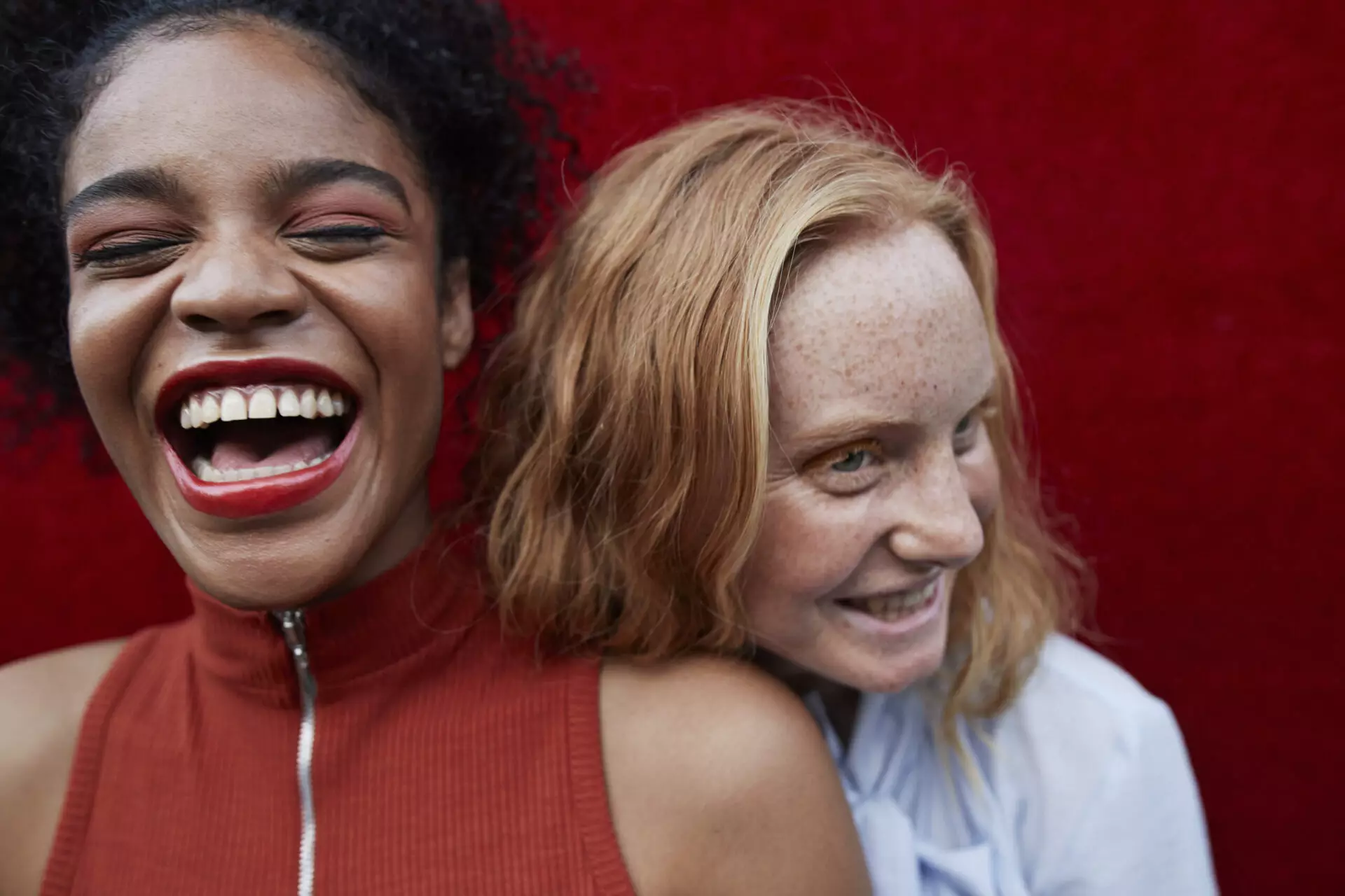 Close-up de mulheres jovens felizes em pé ao ar livre. Klaus Vedfelt/Getty Images