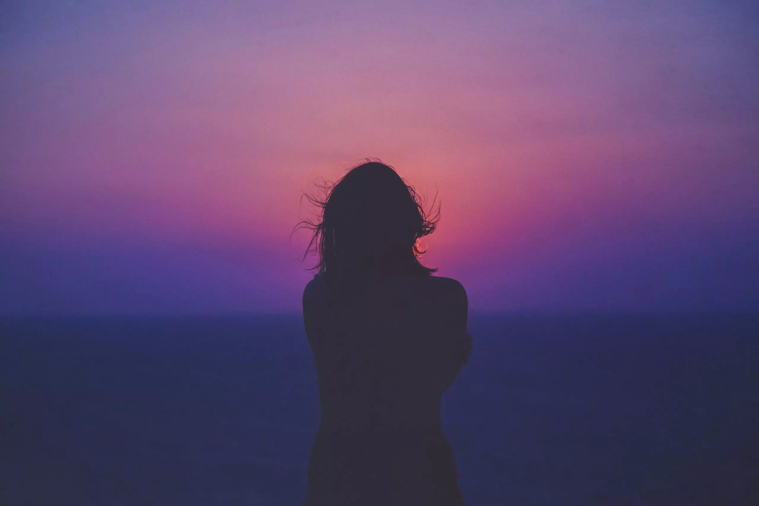 Una silhouette di donna contro un tramonto brillante