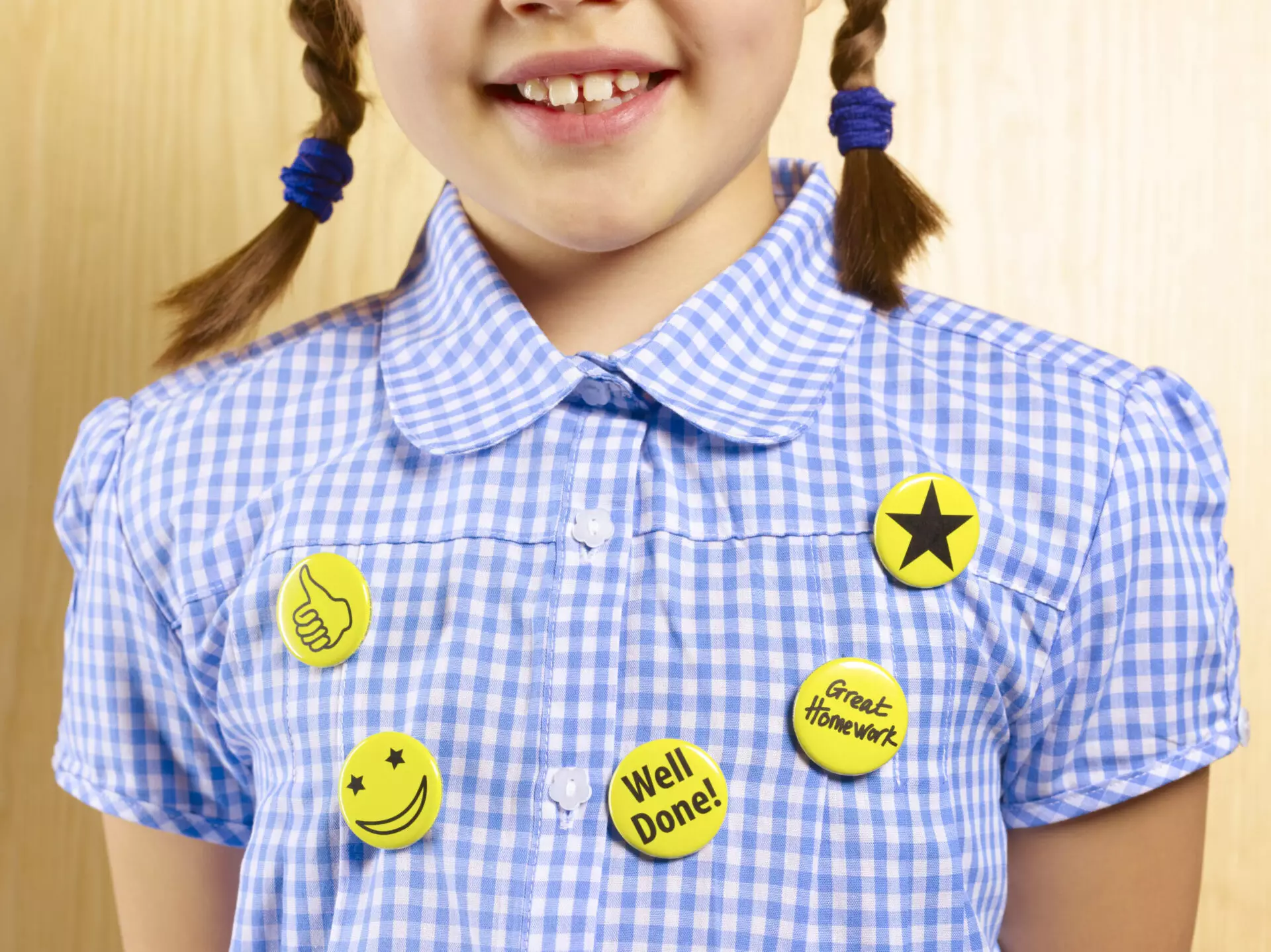 8letá školačka s odznaky tlačítka odměny za dobrou práci.