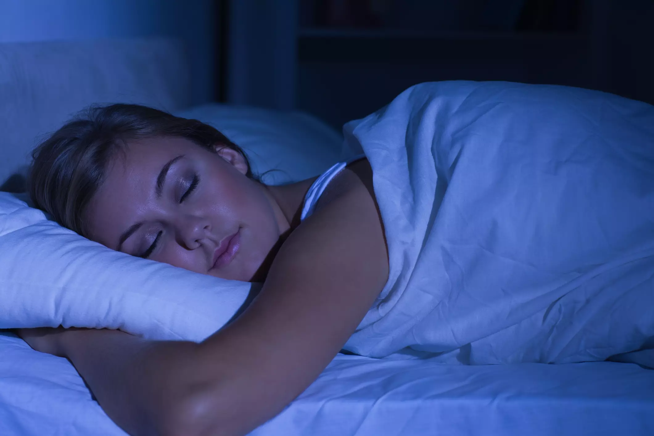 Une femme atteinte de TDAH dort paisiblement après avoir établi une routine saine au coucher
