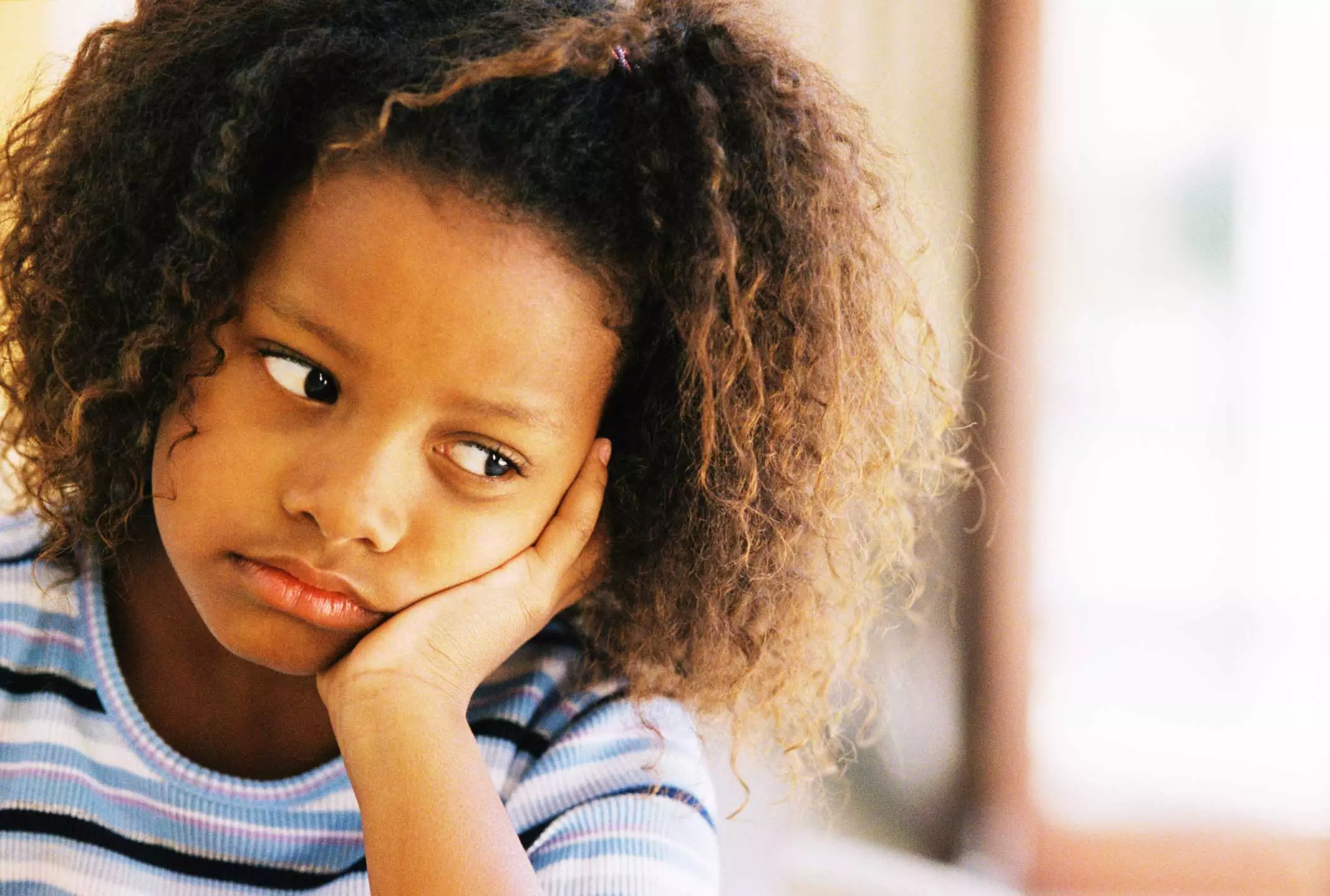 Unha nena triste cunha man na cara ten un trastorno bipolar, que pode ocorrer en nenos con TDAH