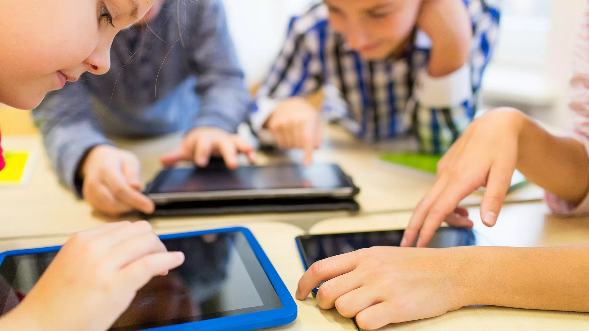 Sekelompok siswa menggunakan alat pembelajaran pada tablet di sekolah.