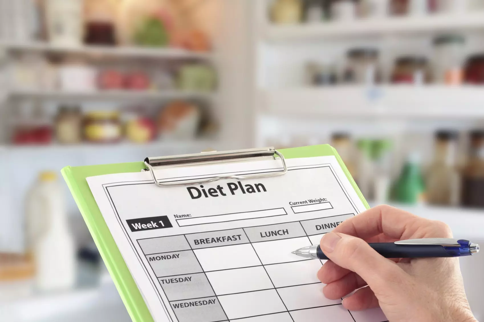 Kobieta pisze plan diety na tydzień, aby pomóc jej osiągnąć cele związane z odchudzaniem z ADHD.