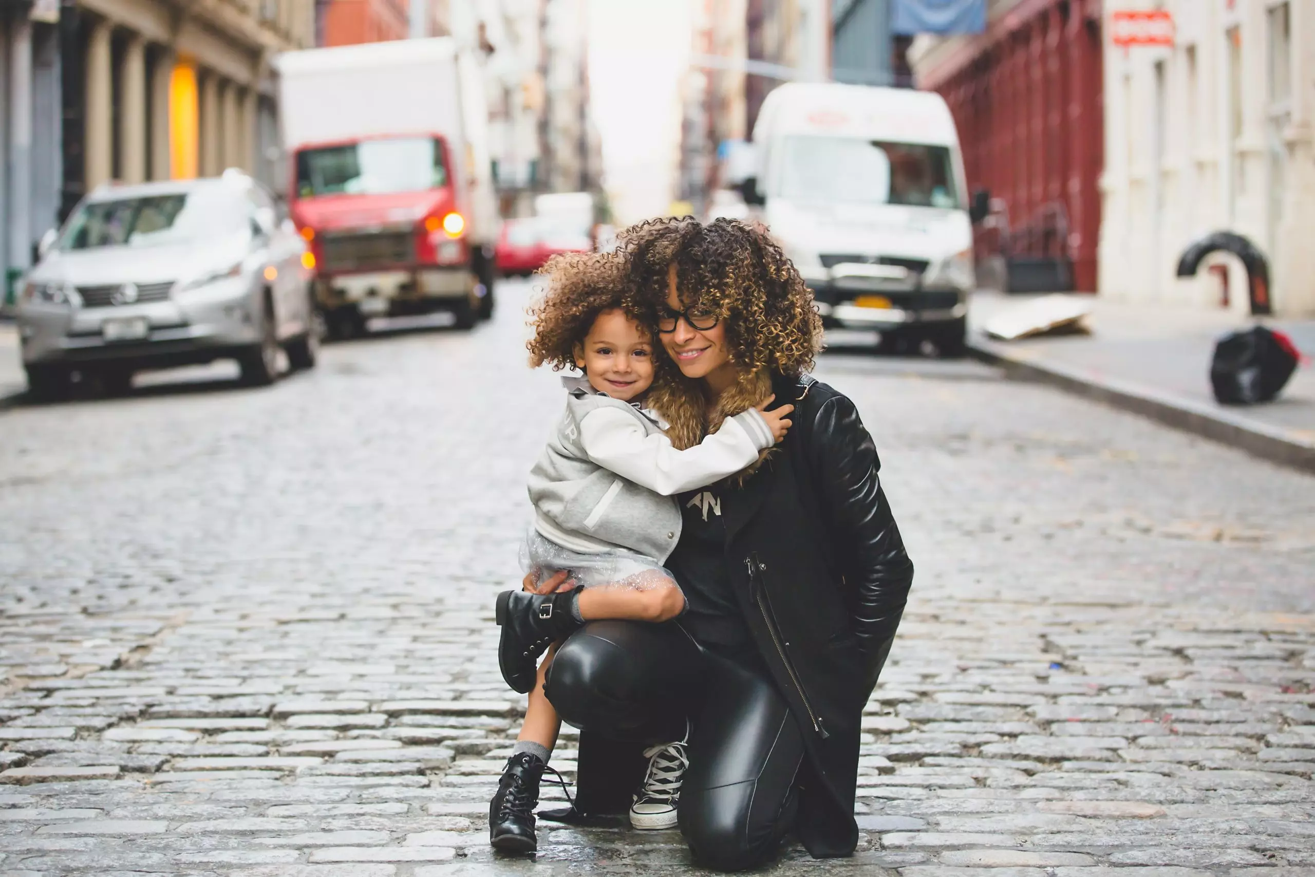 Mama drži hčerko z ADHD na tlakovani ulici