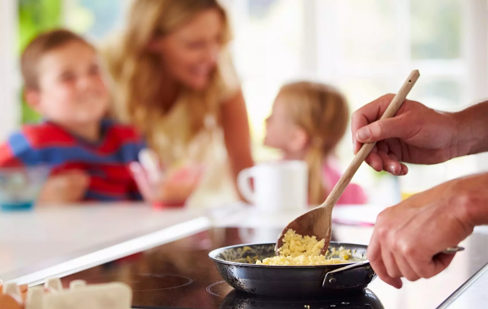 Faðir að útbúa eggjahræru morgunmat fyrir ADHD börn