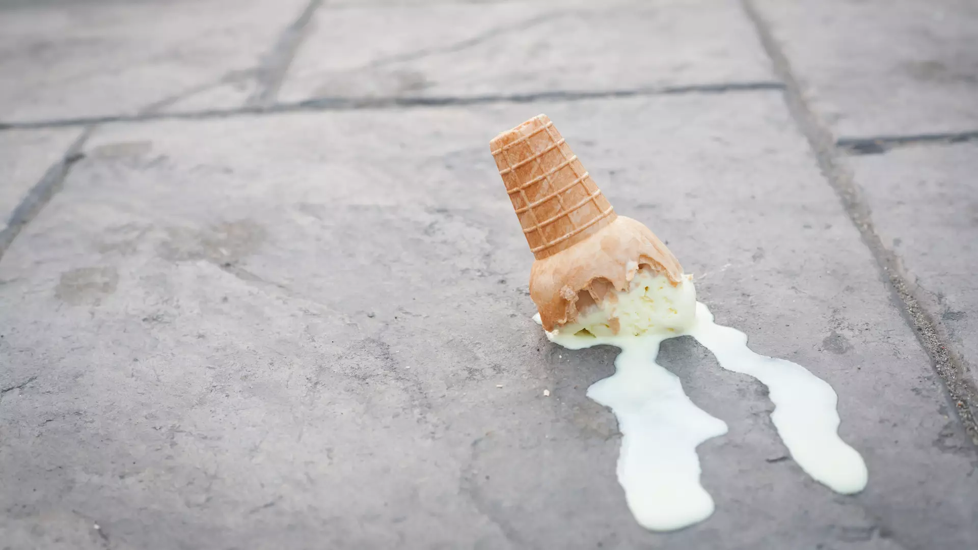Un cono de xeado caído ao chan por un neno torpe