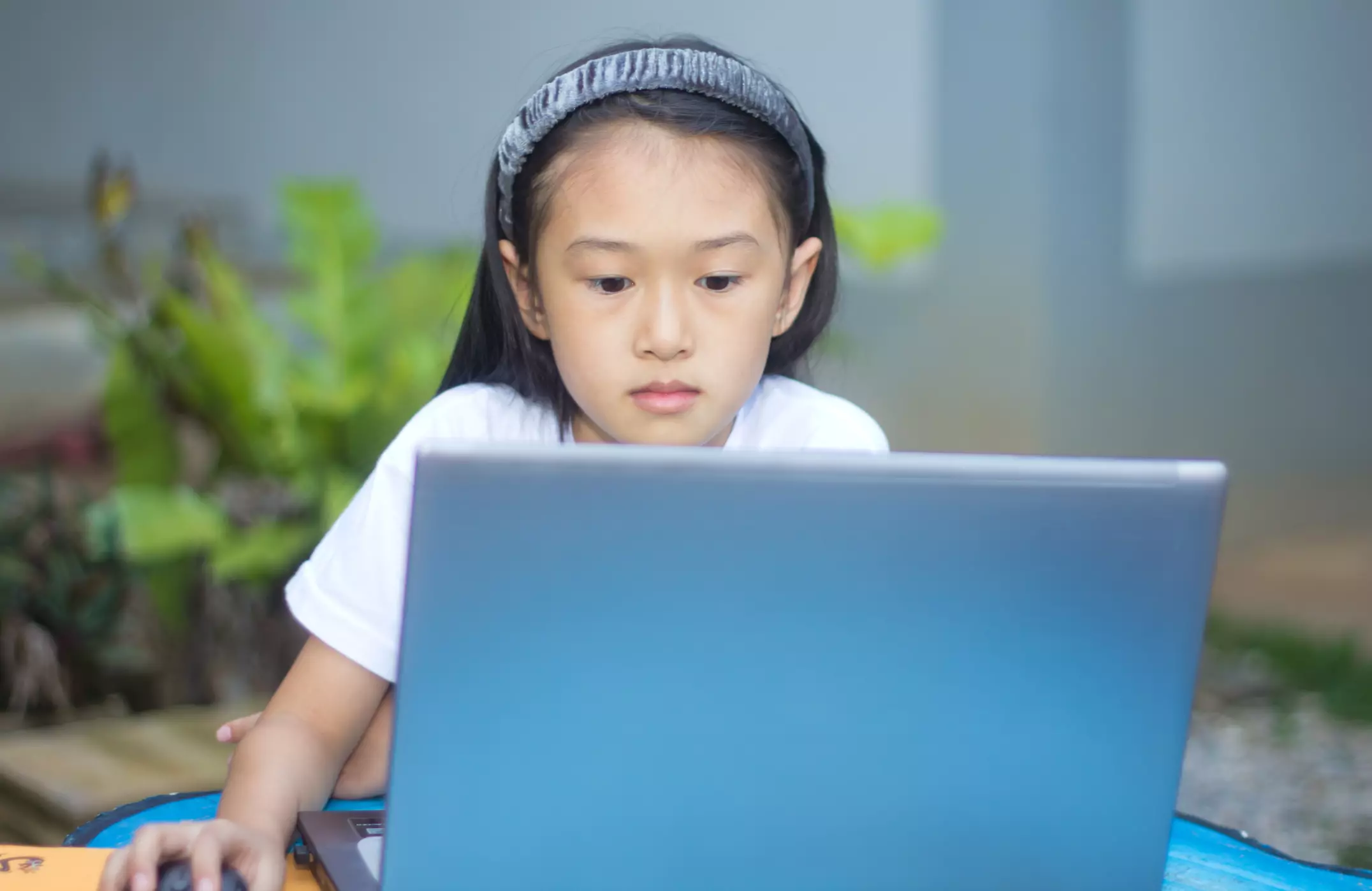 Seorang gadis muda dengan ADHD menggunakan perangkat lunak pendidikan untuk membantunya di sekolah.