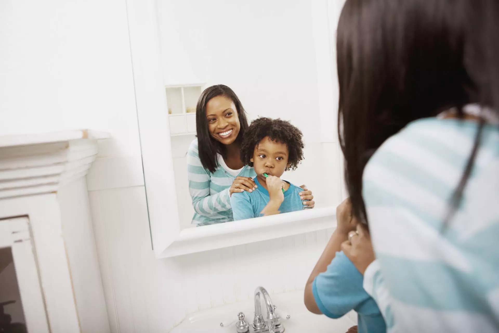 La madre incoraggia il figlio con ADHD e problemi sensoriali mentre si lava i denti con uno spazzolino sensibile