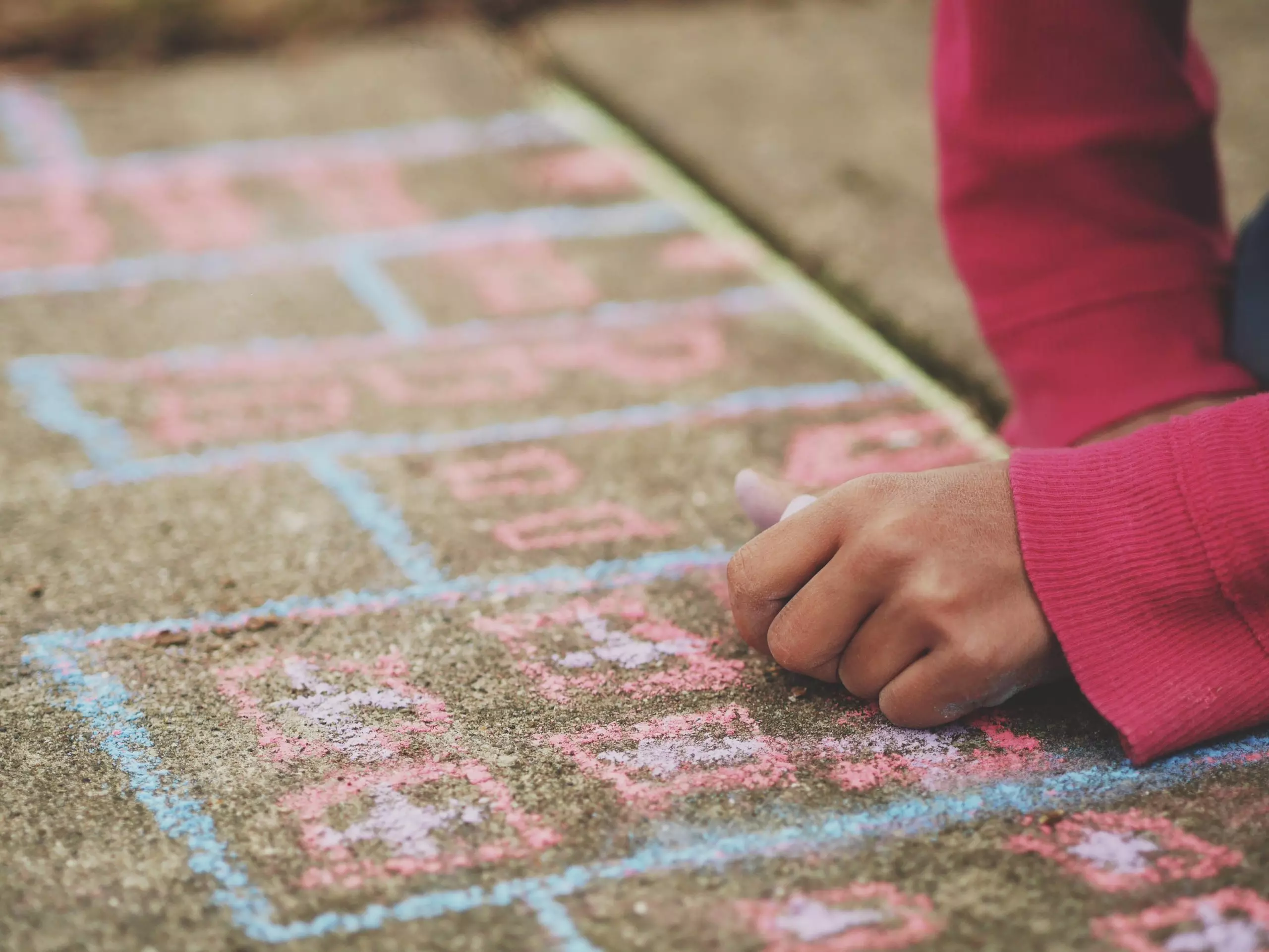 Kinesteetilised õppijad saavad kasu praktilisest kogemusest, nagu see laps, kes joonistab kõnniteele kriidiga