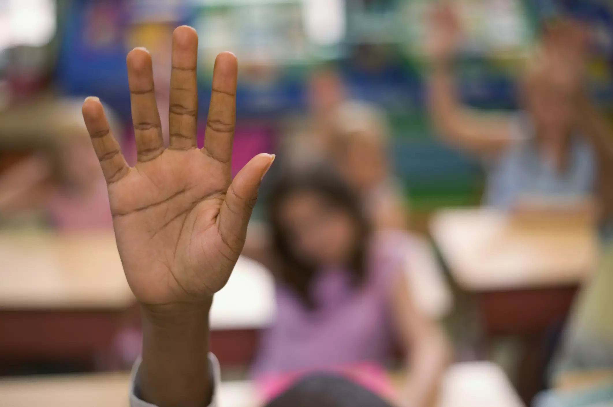 Aluno com TDAH levanta a mão na aula
