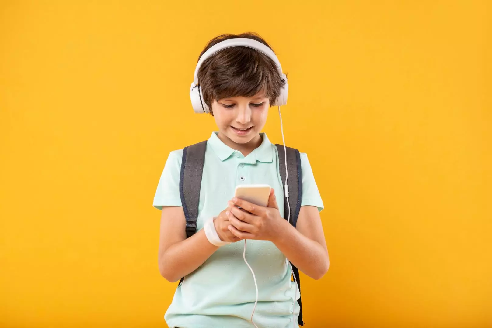 Lapsi kuuntelee musiikkia reppu päällä. Kuinka käyttää musiikkia ADHD-tweenin motivoimiseen aamulla