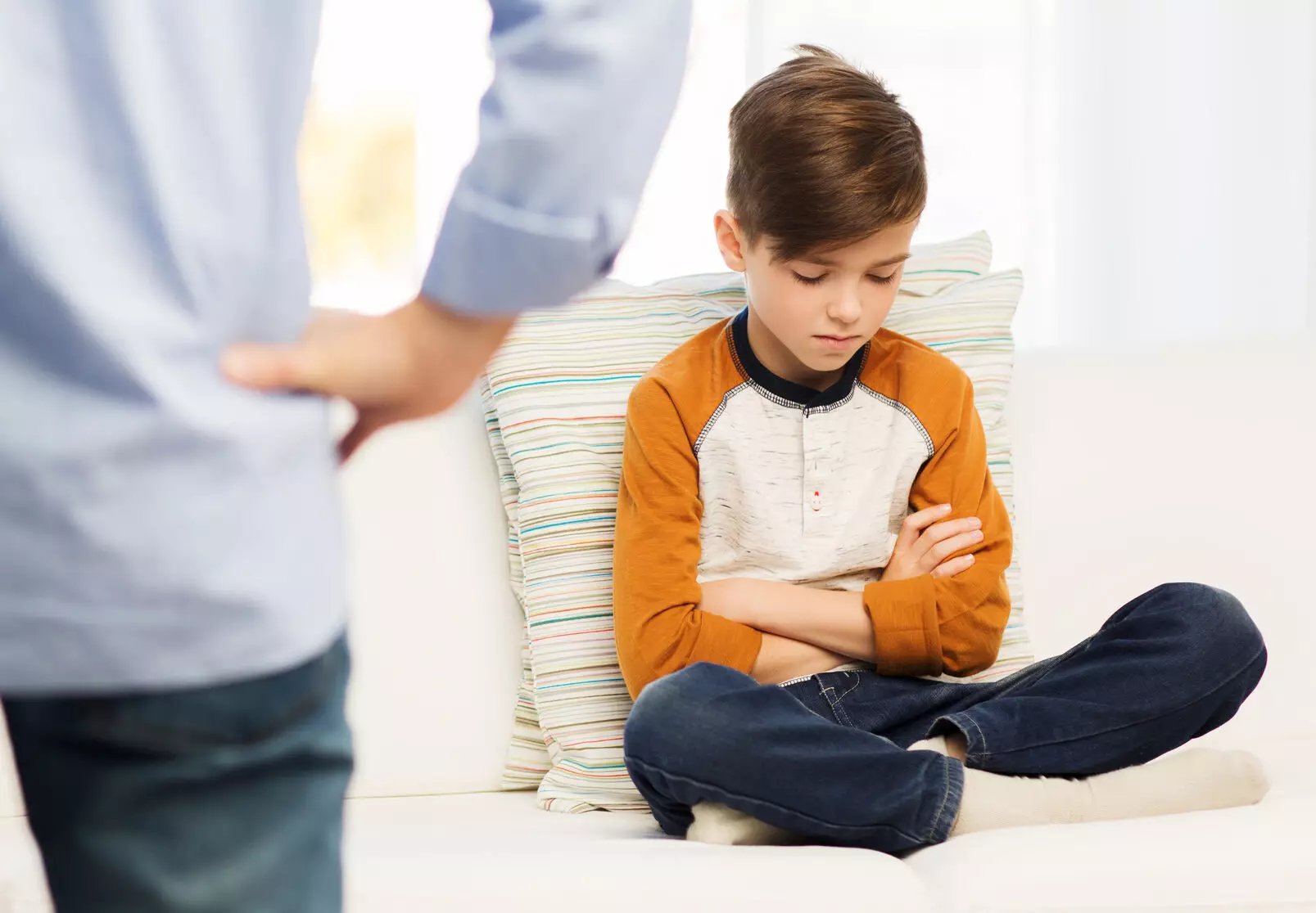 Um menino com TDAH parece desanimado enquanto seu pai com TDAH o disciplina.