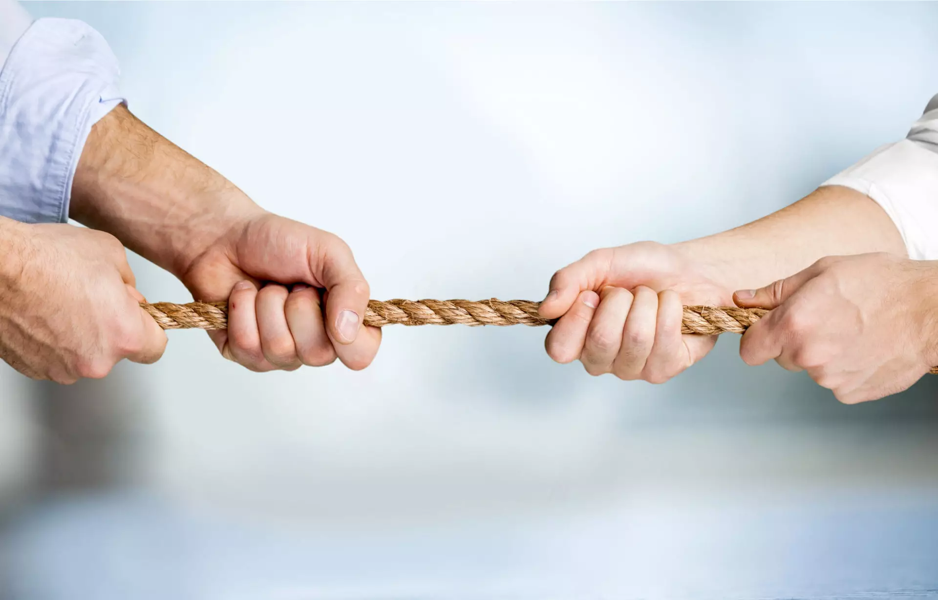 افراد تجاری در حال کشیدن طناب در جهت مخالف در دفتر