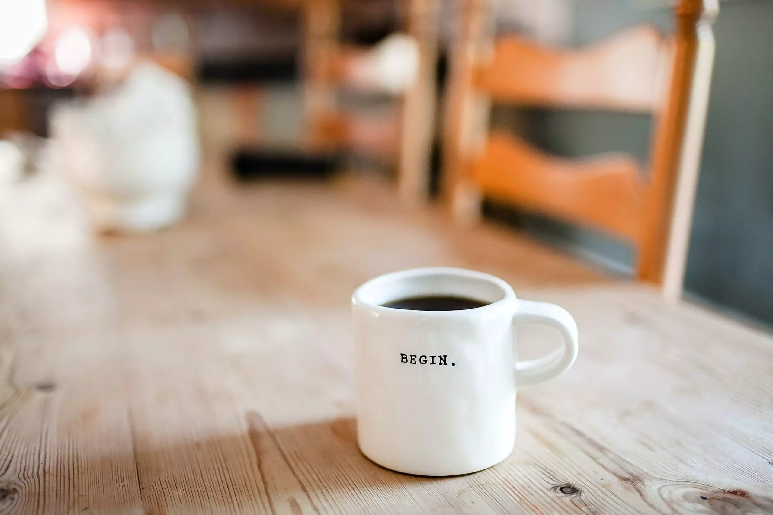 skodelica za belo kavo na mizi z besedo