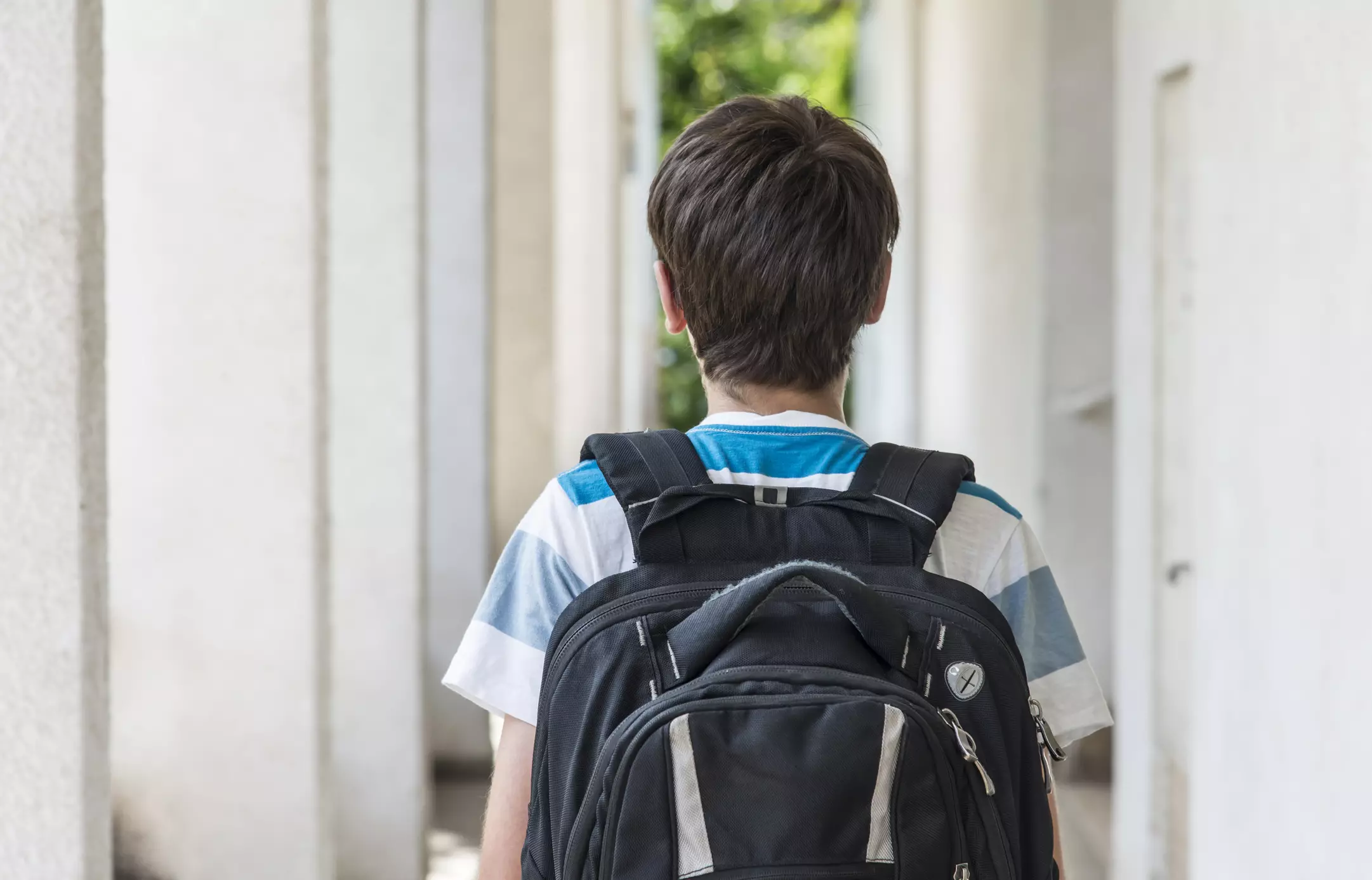 თინეიჯერი სკოლის ბიჭი ADHD-ით ზურგჩანთით სკოლაში მიმავალი