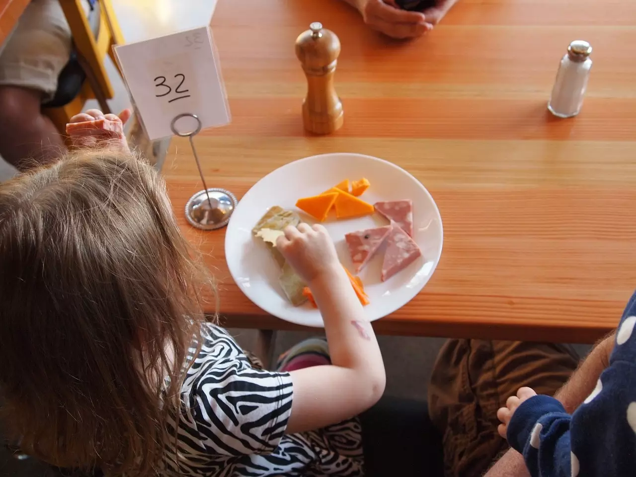 Djevojčica sa ADHD-om jede tanjir hrane u restoranu