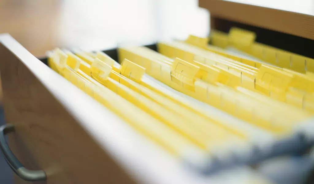 Gaveta aberta cheia de arquivos amarelos em casa organizada