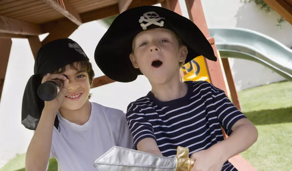 Twee jongens met ADHD die piraten spelen op speelplaats in kostuums