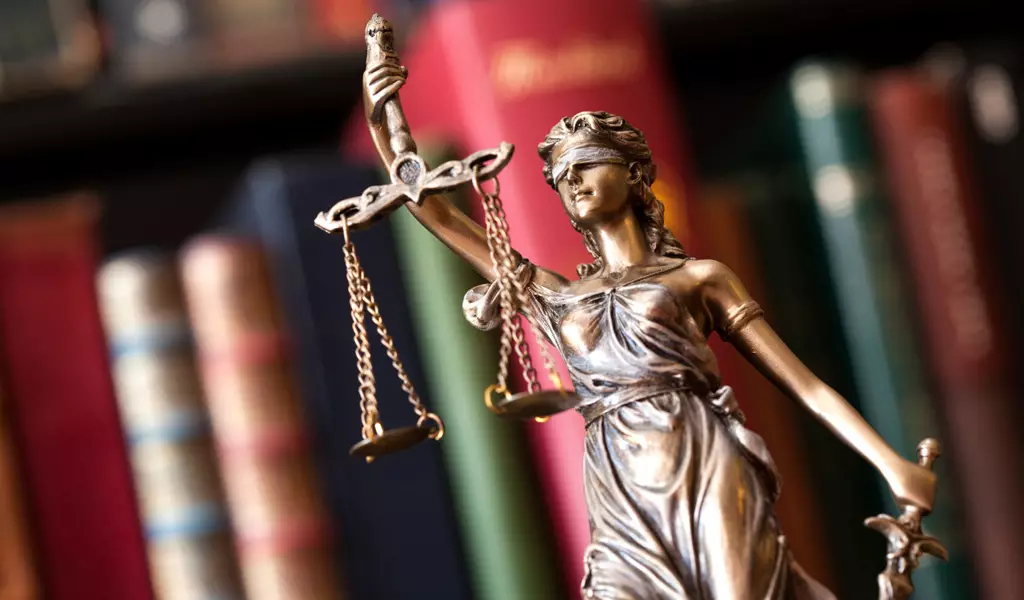 Statue der Gerechtigkeit vor Rechtsbüchern, die das gesetzliche Recht von Menschen mit ADHS darstellen