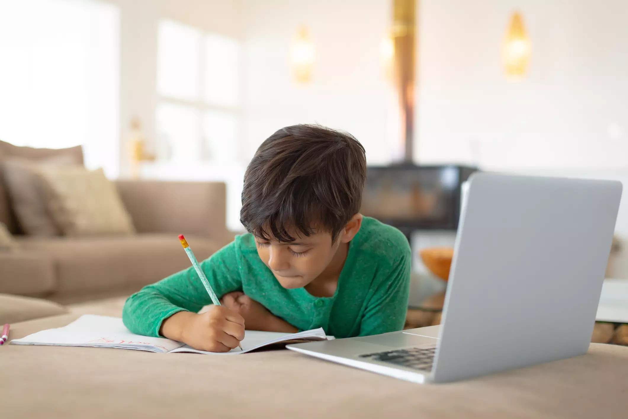Un enfant prenant des notes dans le cadre d'un programme d'apprentissage à domicile