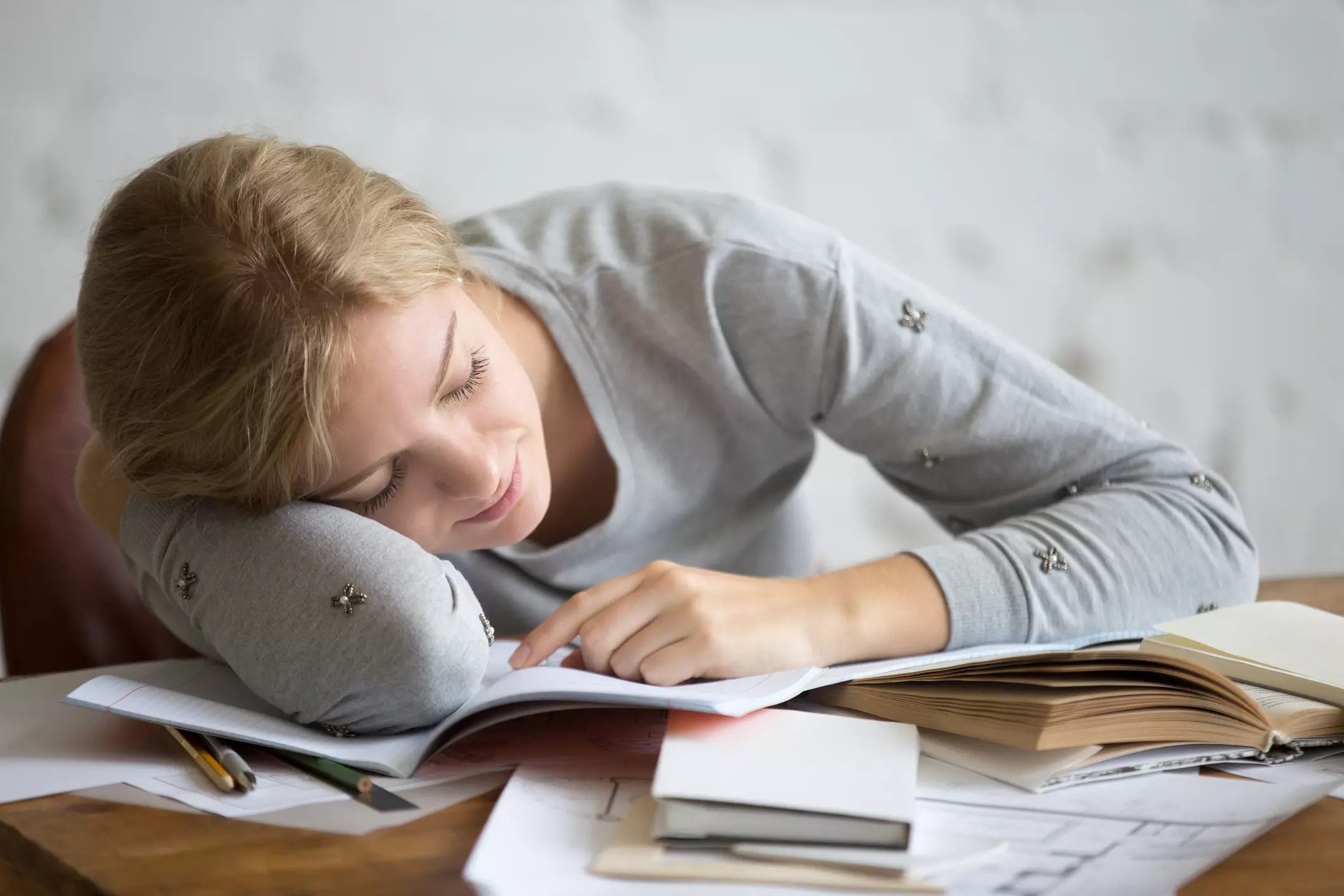 Retrato de una estudiante con TDAH durmiendo en el escritorio