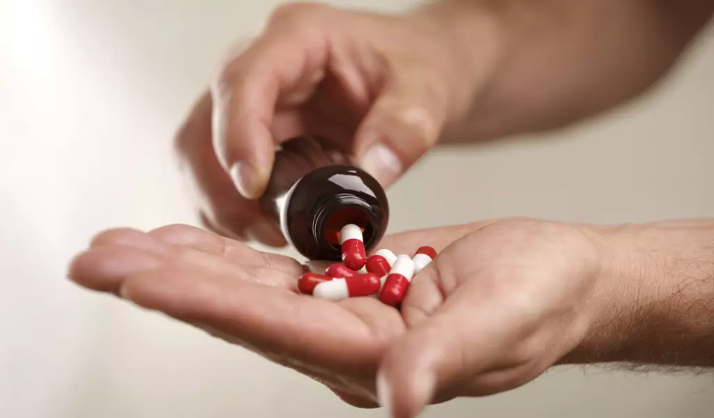 Person mit ADHS und Suchtproblemen leert Medikamentenflasche in die Hand
