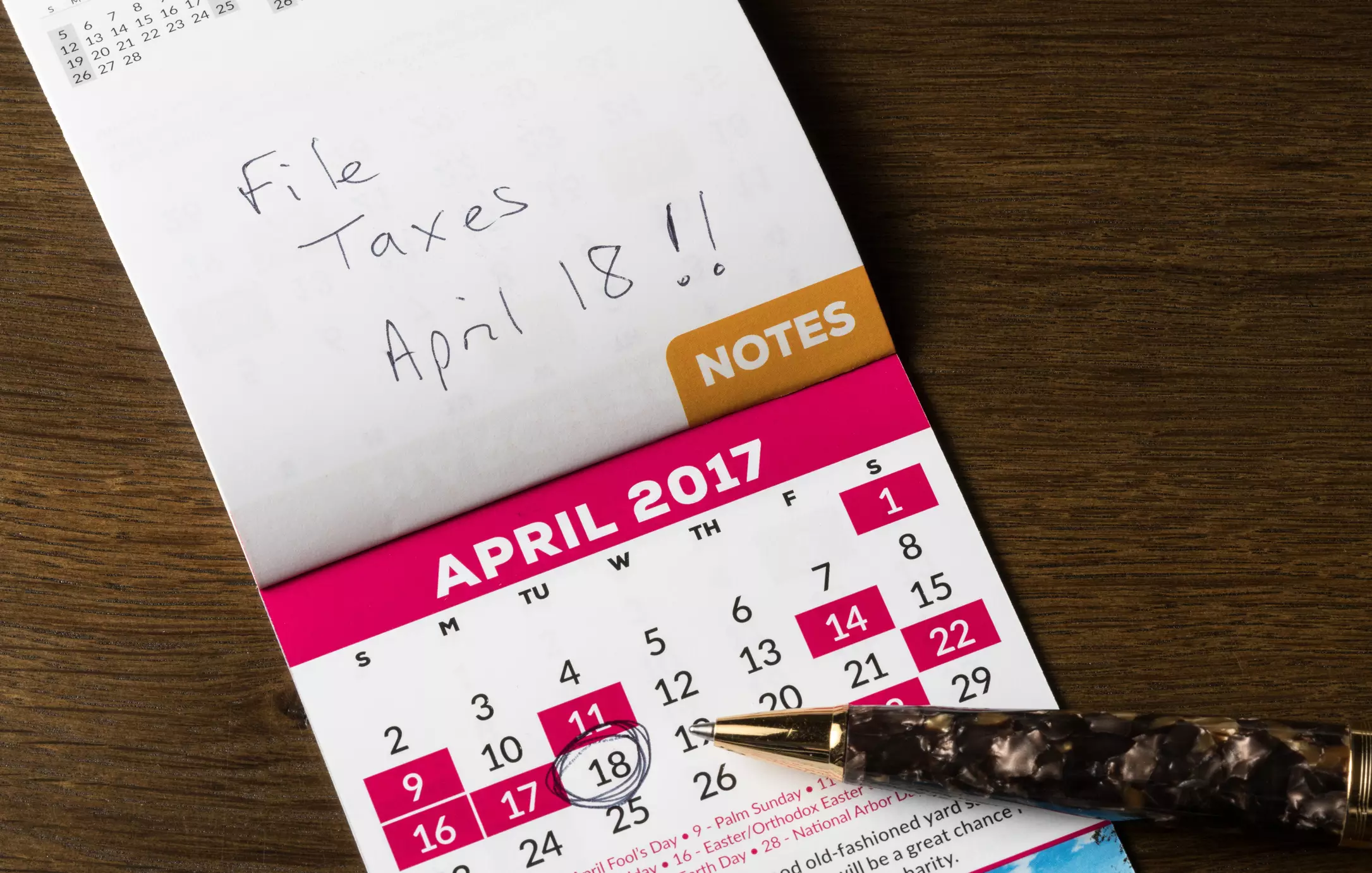 Goldener Stift, der für den Steuertag auf den Kalender einer ADHS-Person legt