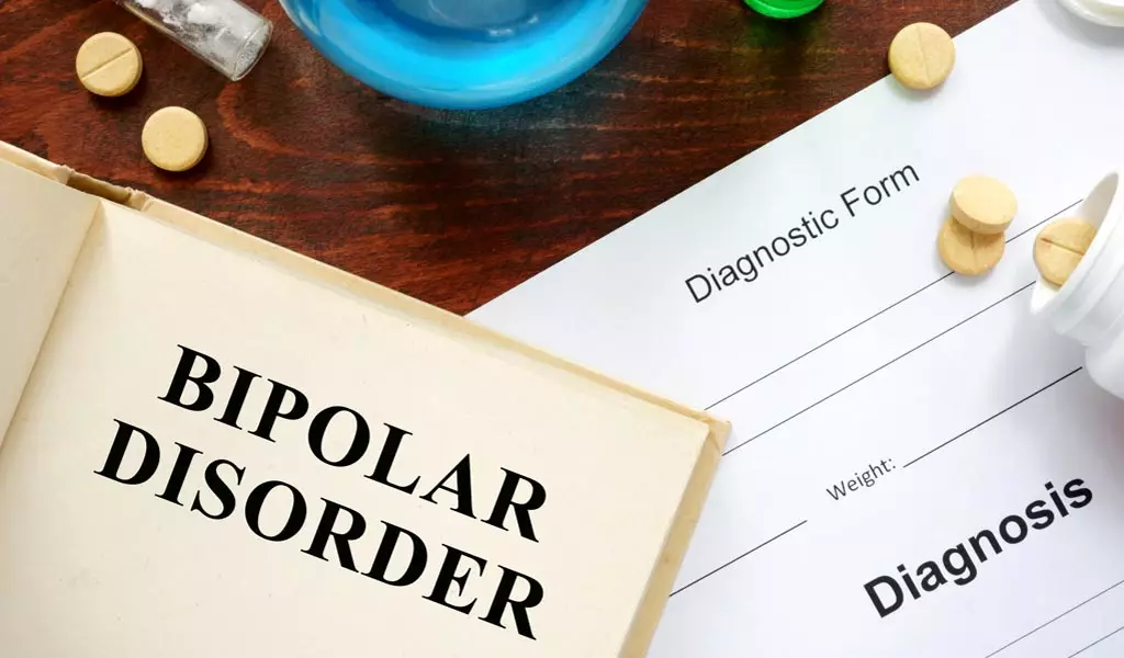Mag-book tungkol sa bipolar disorder na may diagnostic form sa tabi nito na napapalibutan ng iba't ibang uri ng gamot