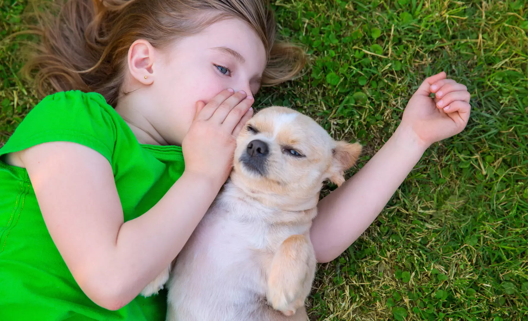 Niña con trastorno del procesamiento del lenguaje susurrando secretos a un cachorro astuto