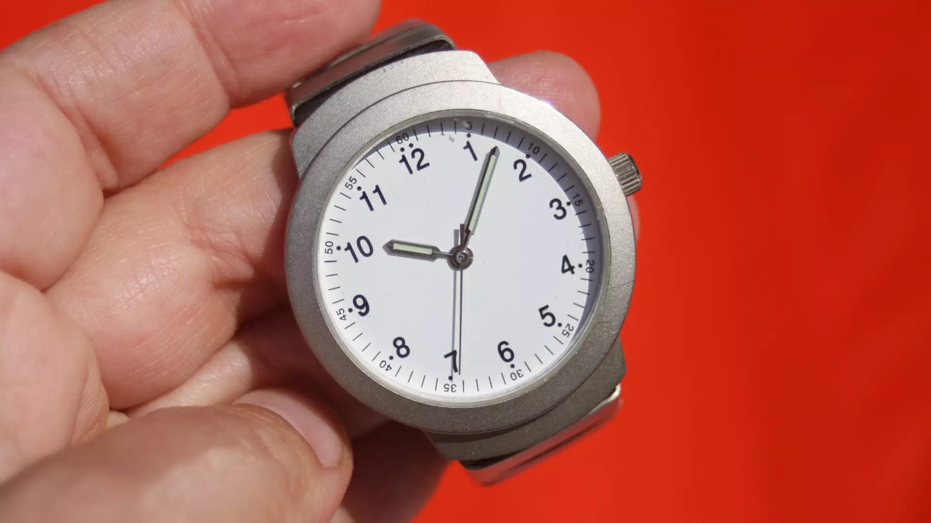 Чоловік тримає годинник, за яким навчатиме дітей планувати час
