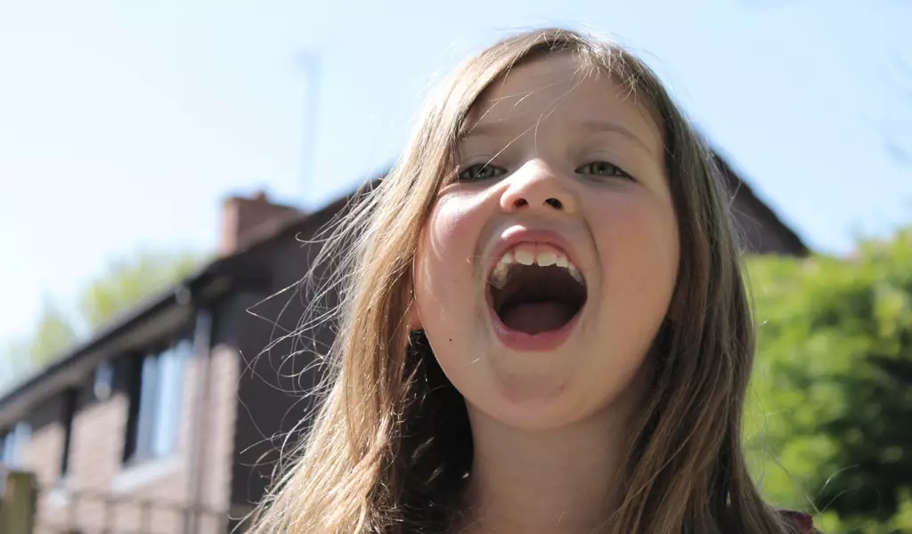 Mladé dievča s neverbálnou poruchou učenia, nie ADHD, kričí pred svojím domom