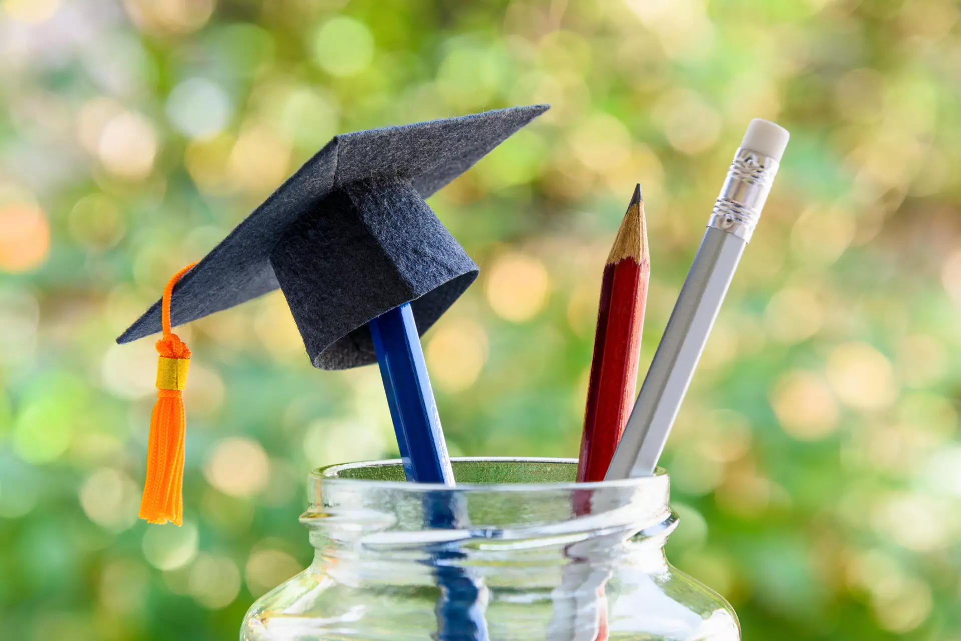 L'éducation et les connaissances sont importantes pour l'étudiant et le concept d'arme le plus puissant : le chapeau noir de graduation ou le chapeau sur le crayon en bouteille, dépeint le pouvoir du succès dans l'éducation. Fond de nature verte.