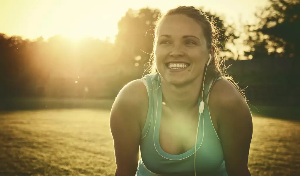 ایک دوڑ کے بعد مسکراتی ہوئی عورت، بالغوں میں ADHD کے بہت سے قدرتی علاج میں سے ایک
