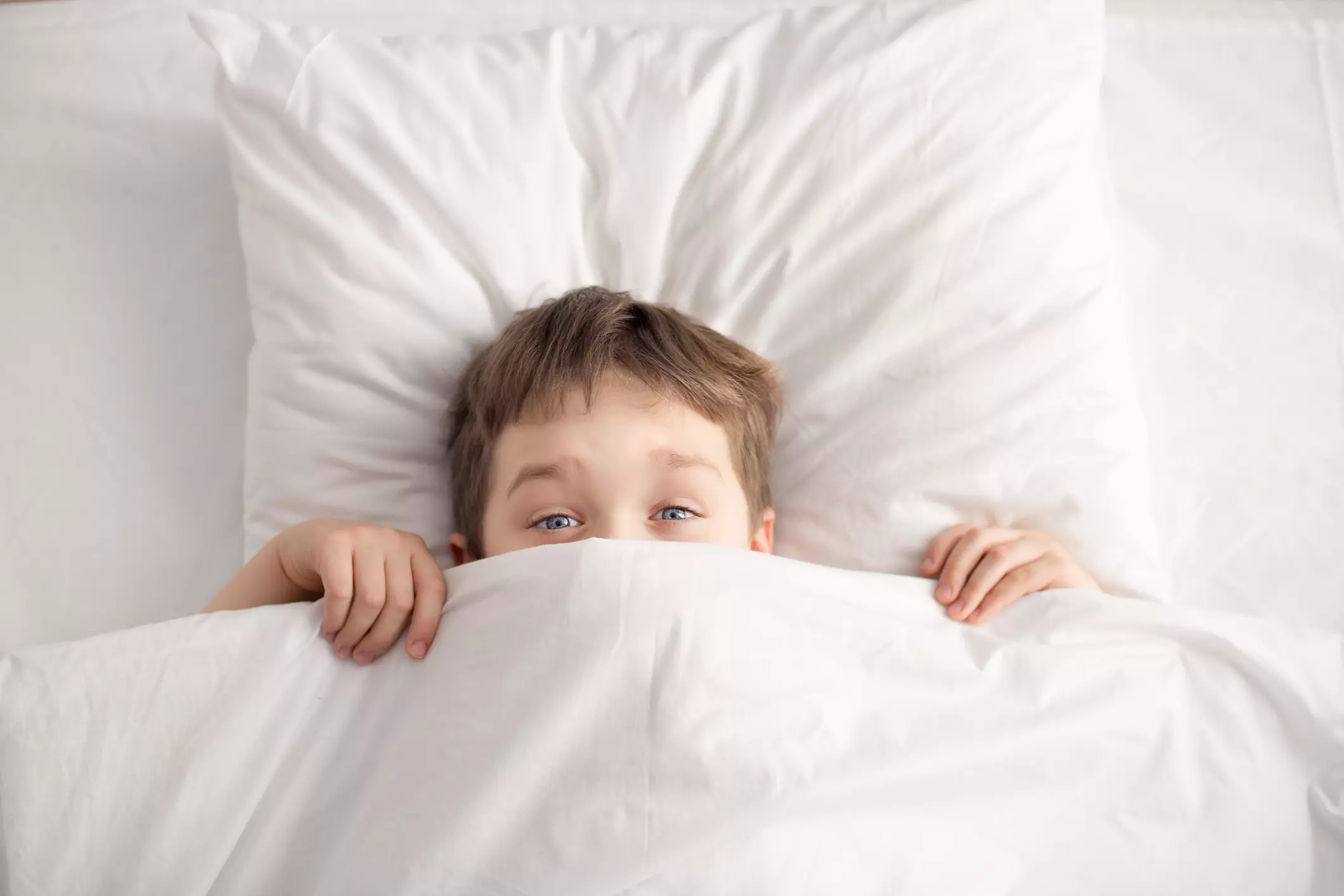 Een jongen kan 's ochtends niet wakker worden, een aandoening die veel voorkomt bij kinderen met adhd.
